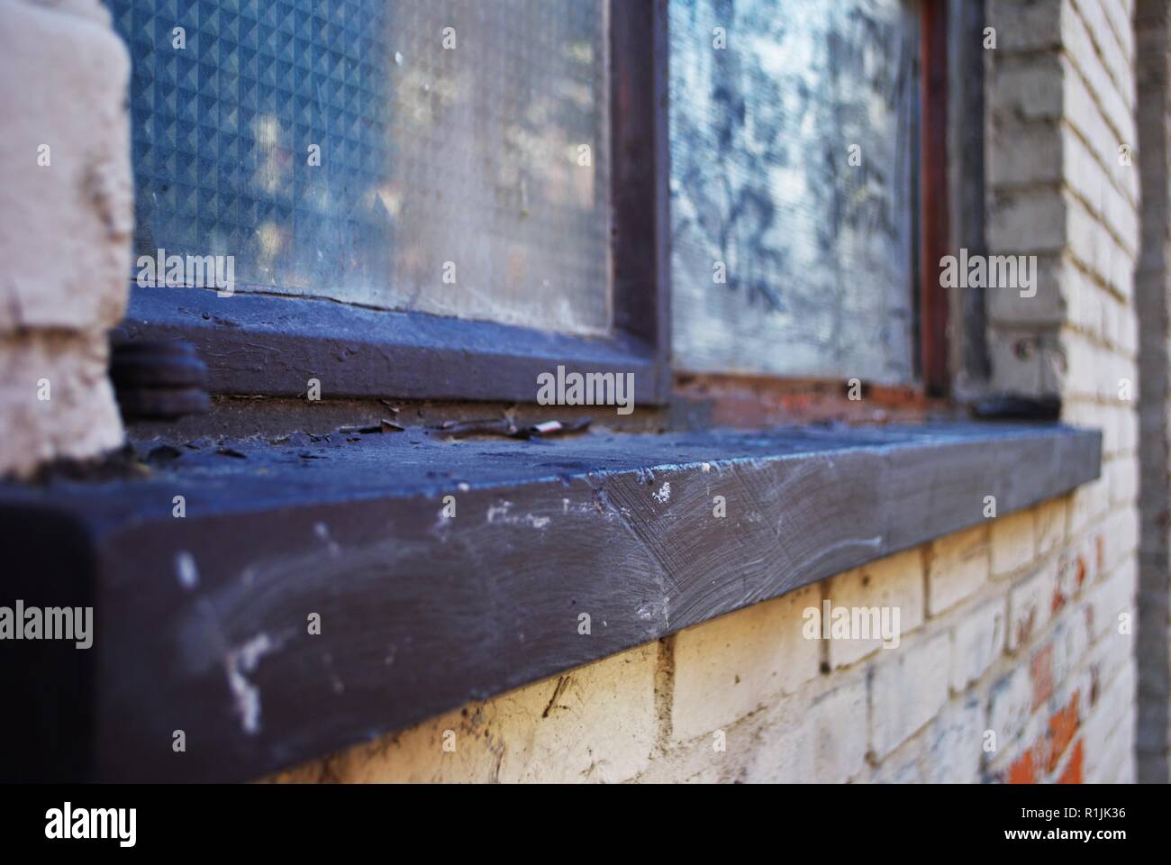Close up of a dirty broken boarded up window sill on an abandoned ...
