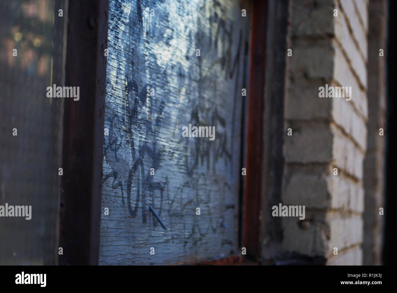 Close up of a dirty broken boarded up window sill on an abandoned ...