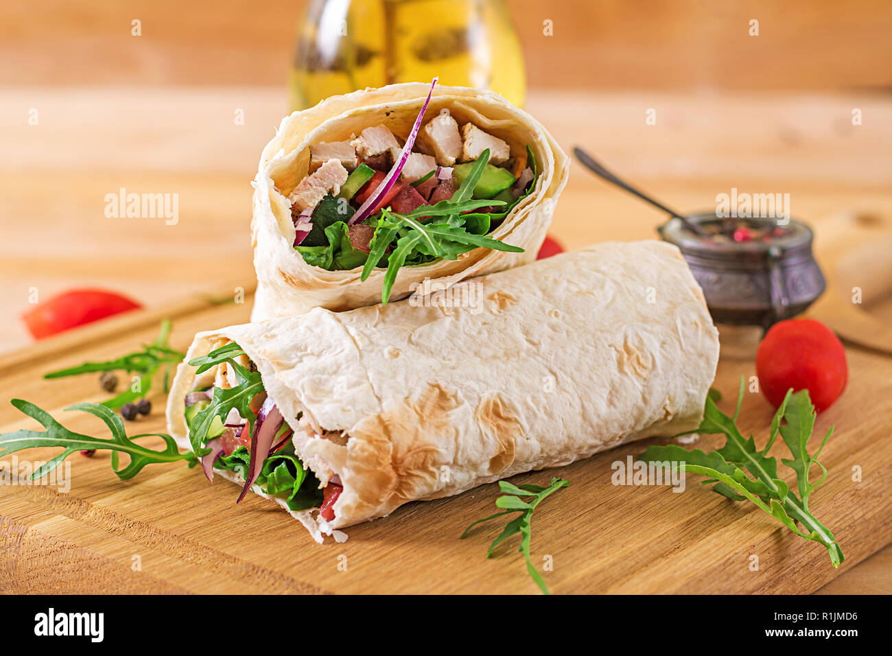 Tortillas wraps with chicken and vegetables on wooden background ...