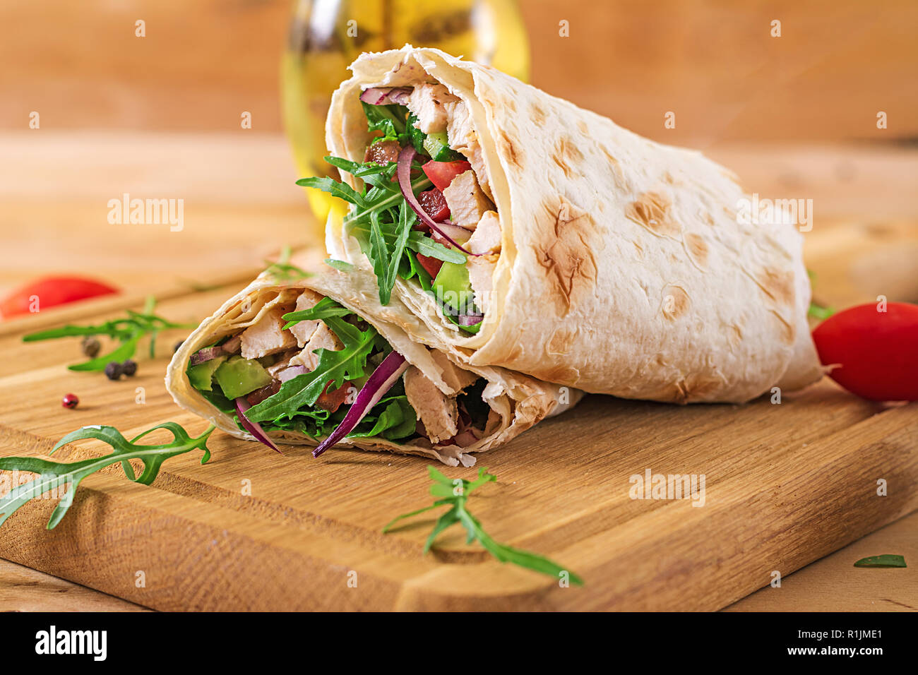 Tortillas wraps with chicken and vegetables on wooden background ...