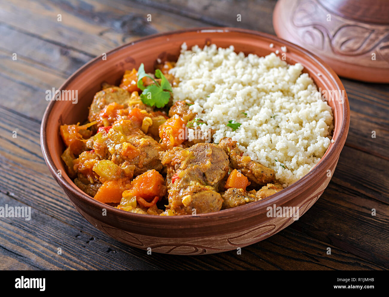 Traditional tajine dishes, couscous and fresh salad on rustic wooden ...