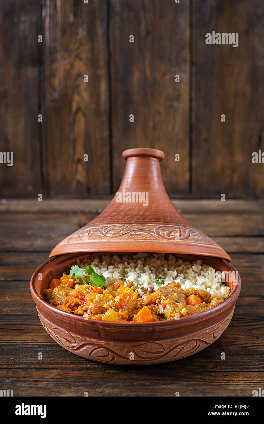 Traditional tajine dishes, couscous and fresh salad on rustic wooden ...