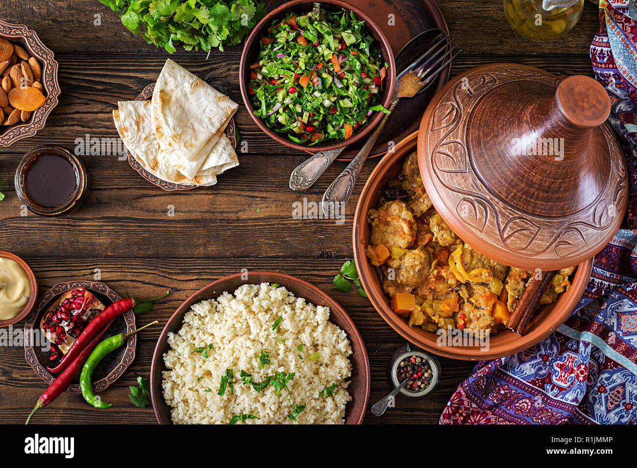 Traditional tajine dishes, couscous and fresh salad on rustic wooden ...