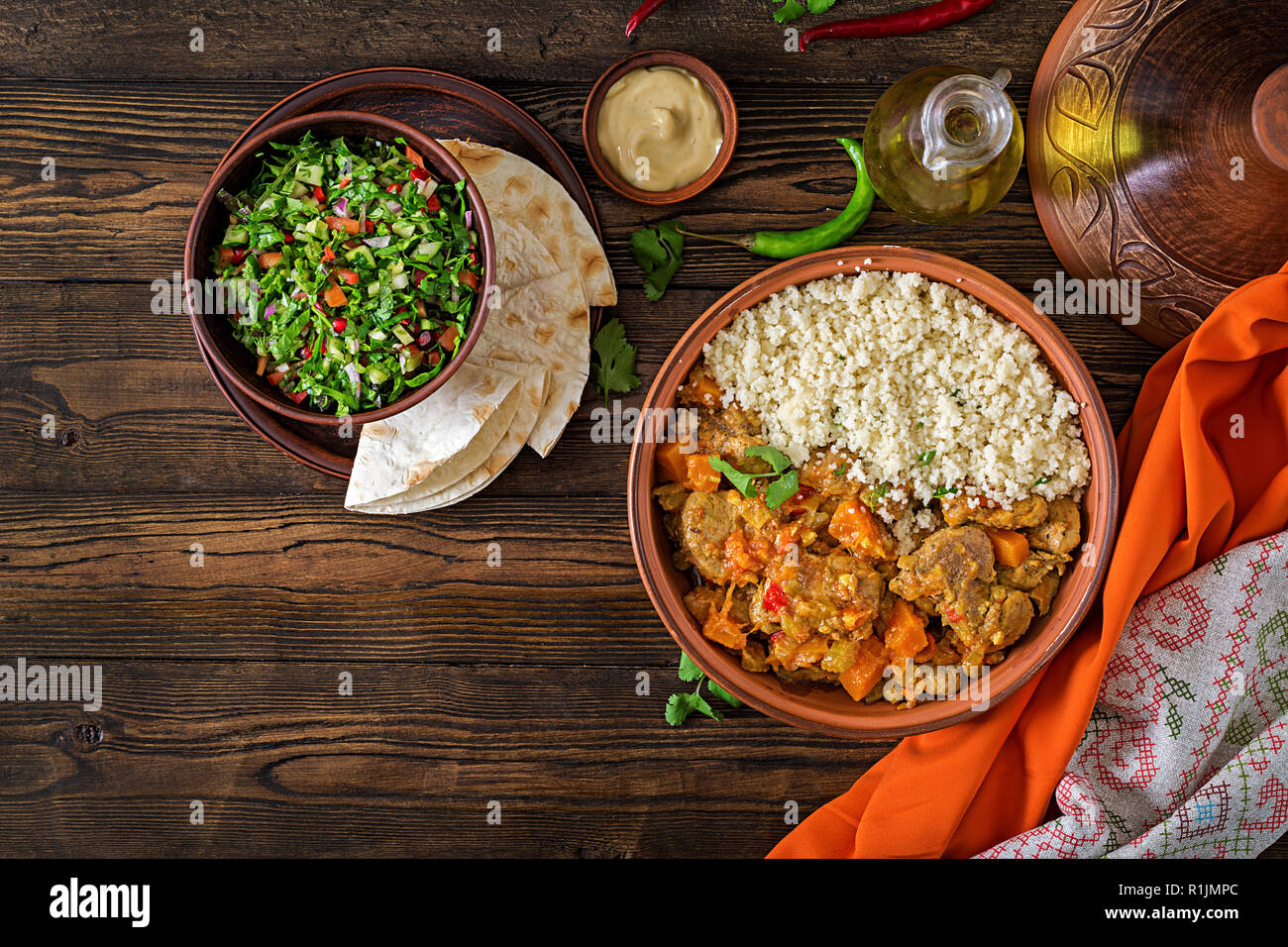 Traditional tajine dishes, couscous and fresh salad on rustic wooden ...