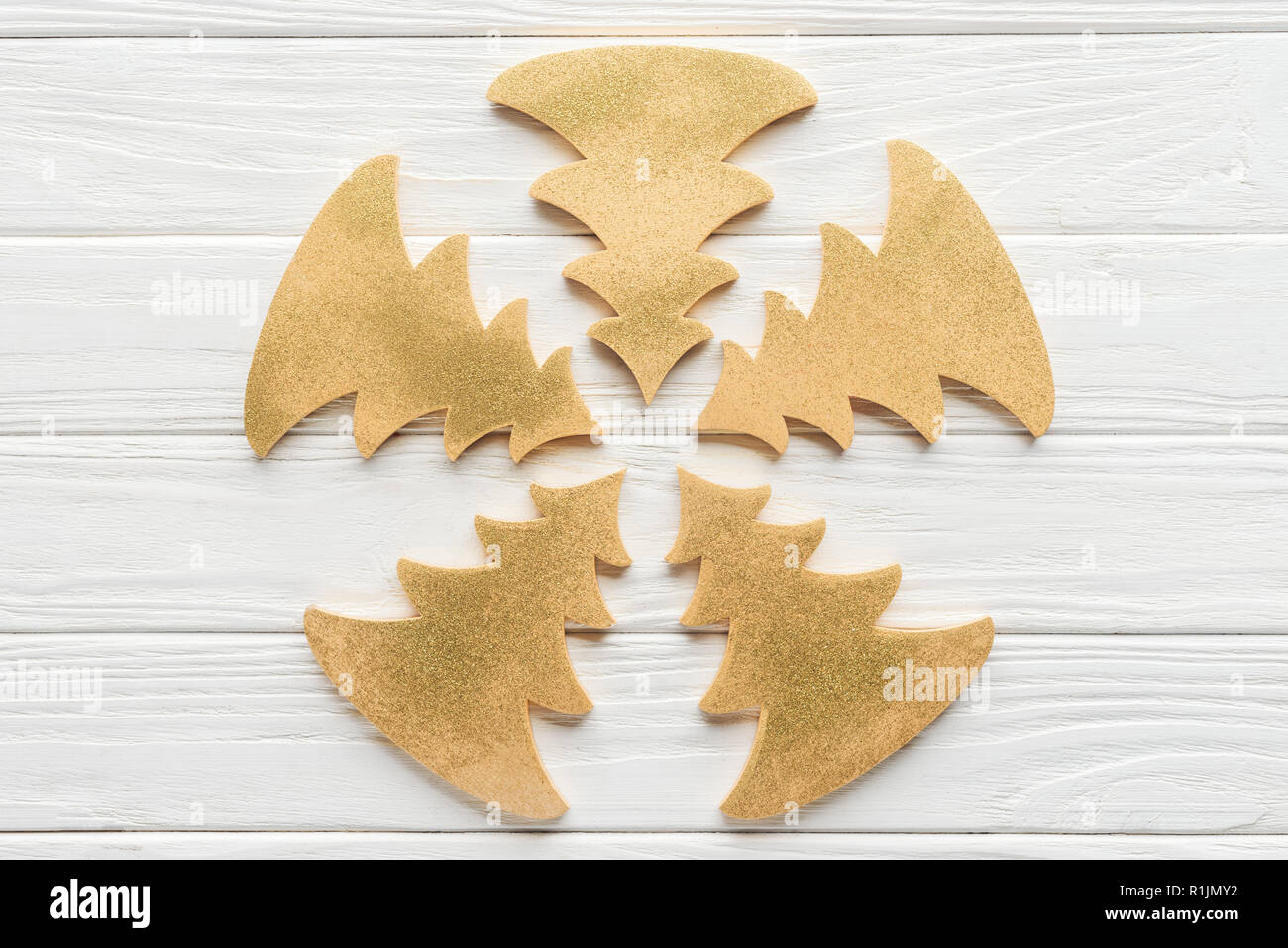 top view of arranged decorative golden pine trees on white wooden ...