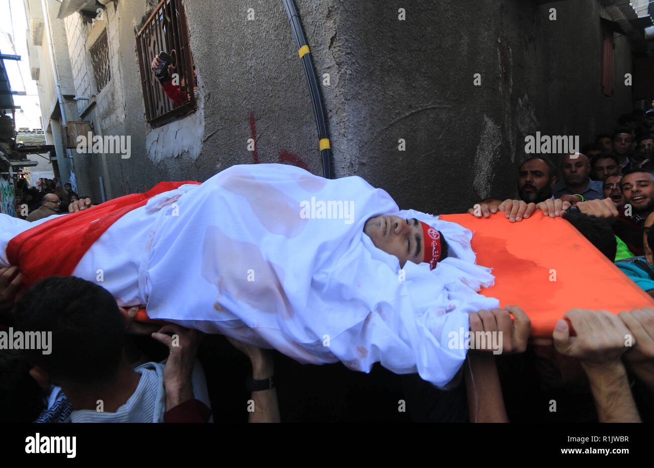 Jabalia, Gaza Strip, Palestinian Territory. 13th Nov, 2018. Mourners carry the body of ...