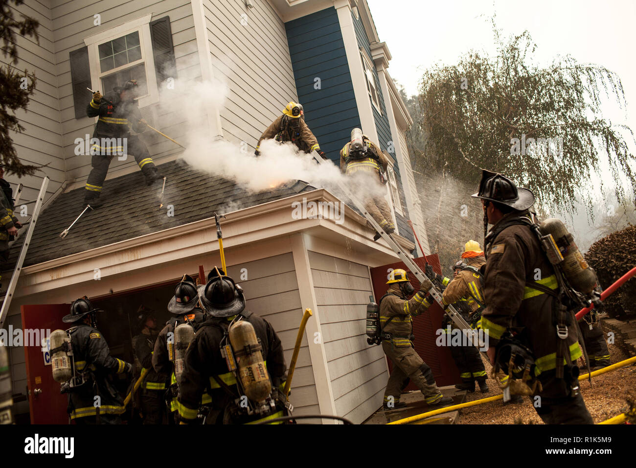Firefighters work to extinguish a corner of the Paradise Best Western ...