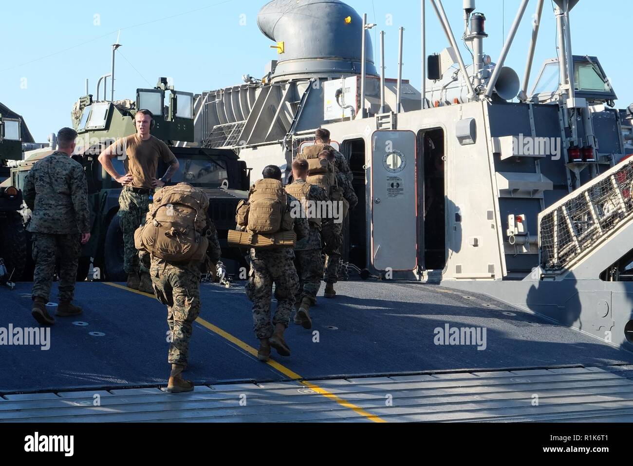 U.S. Marines walk onto the loading ramp of a Landing Craft Air Cushion ...