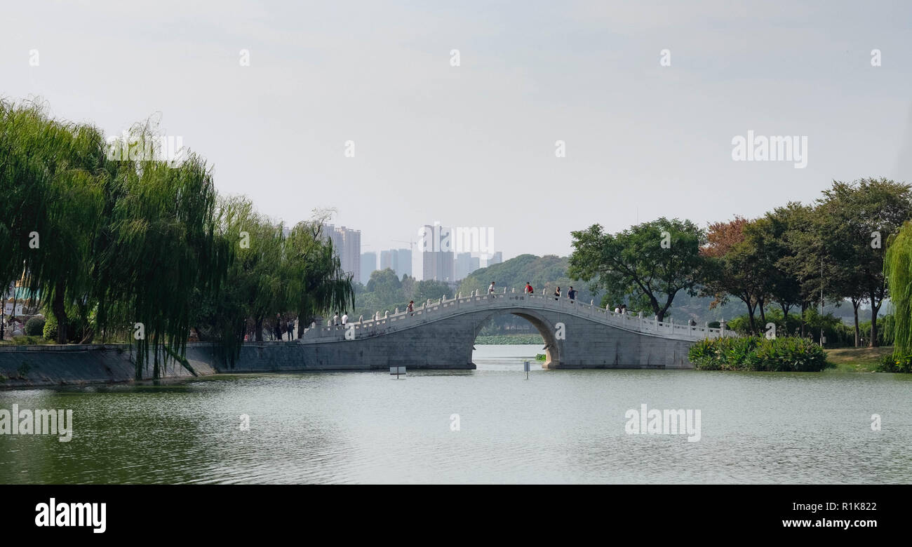 White stone footbridge in an Chinese garden lacated among the modern ...