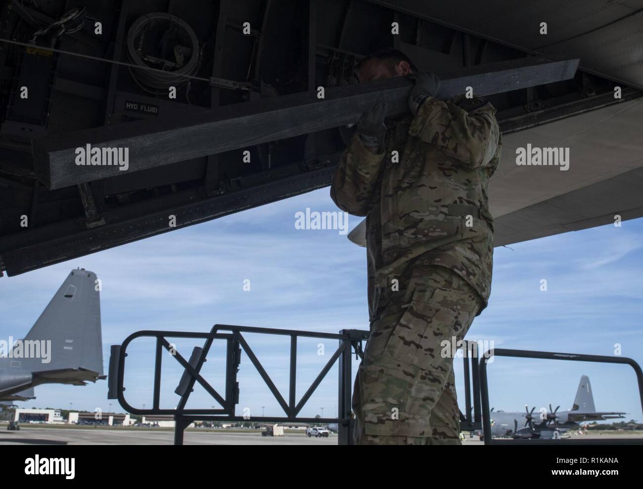 An aircrew member with the 15th Special Operations Squadron loads cargo ...