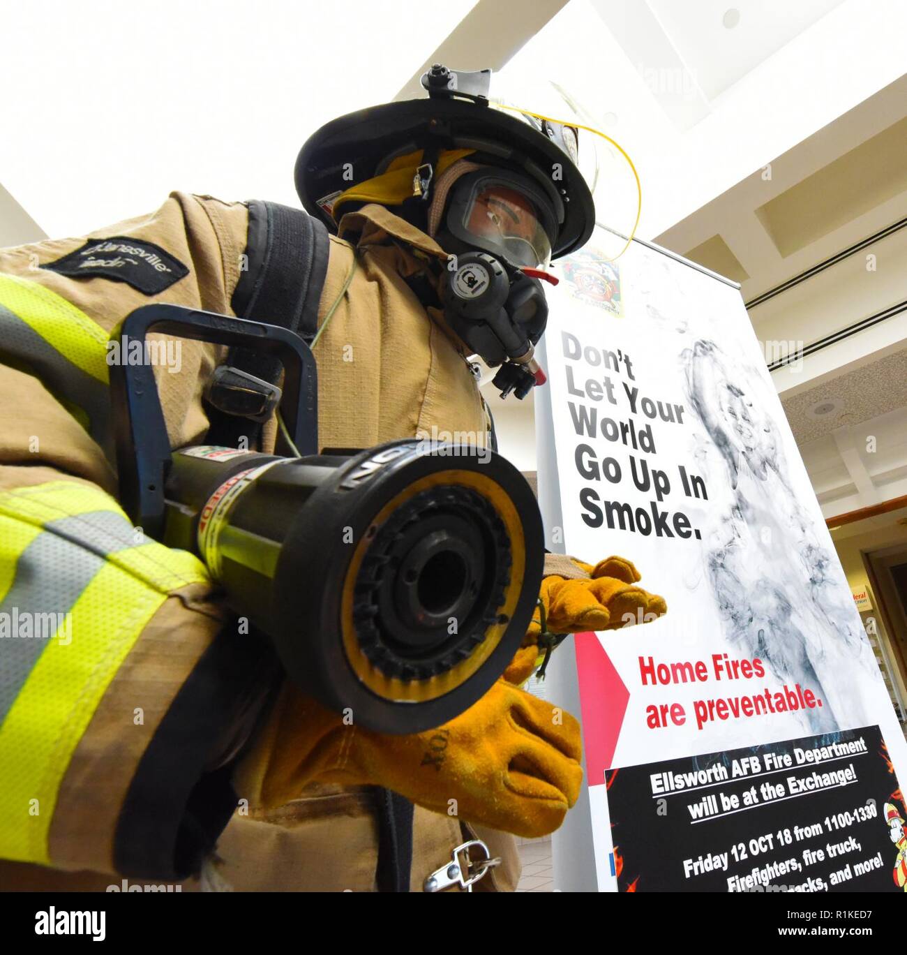 A training dummy dressed like a firefighter stands next to a fire ...