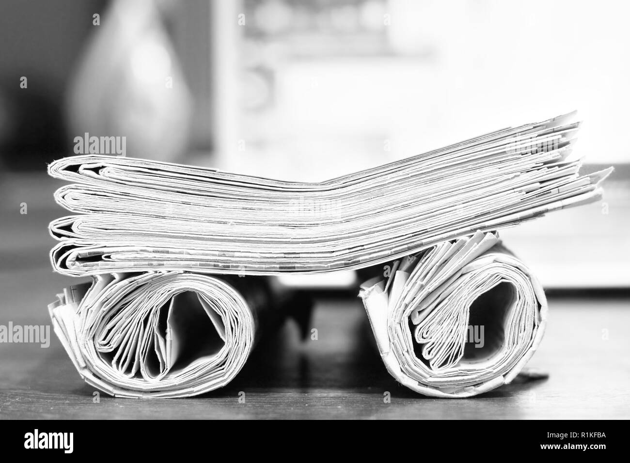 Rolled and folded newspaper looks like paper car with wheels, open ...