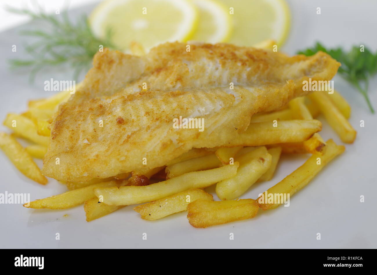 fried cod fish fillet on a plate with parsley and lemon Stock Photo - Alamy