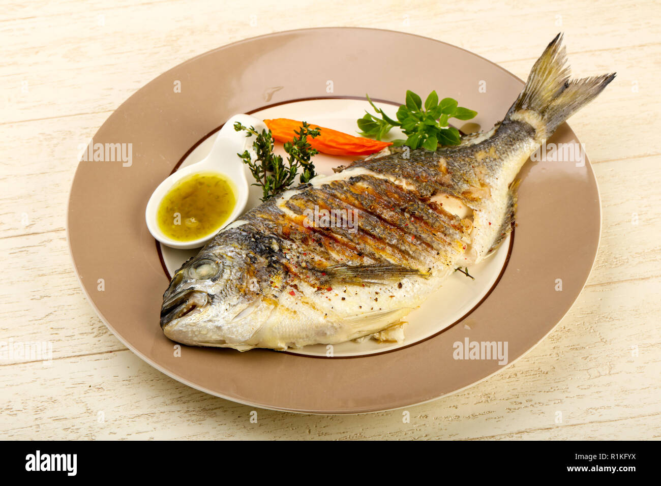 Grilled dorado fish with sauce, thyme and basil Stock Photo - Alamy