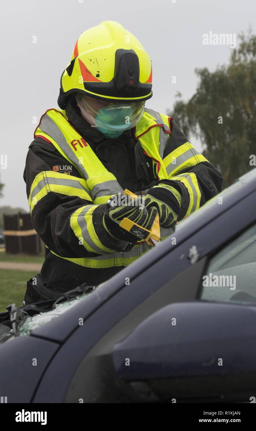 A firefighter, with the 423rd Civil Engineer Squadron, saws off a car ...