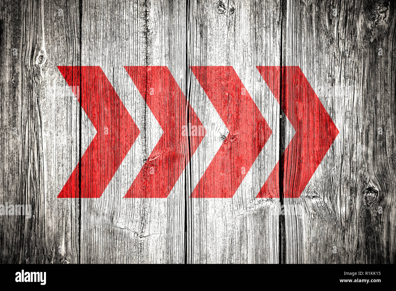 Red directional arrow signs pointing direction over old grungy and weathered white and grey ...