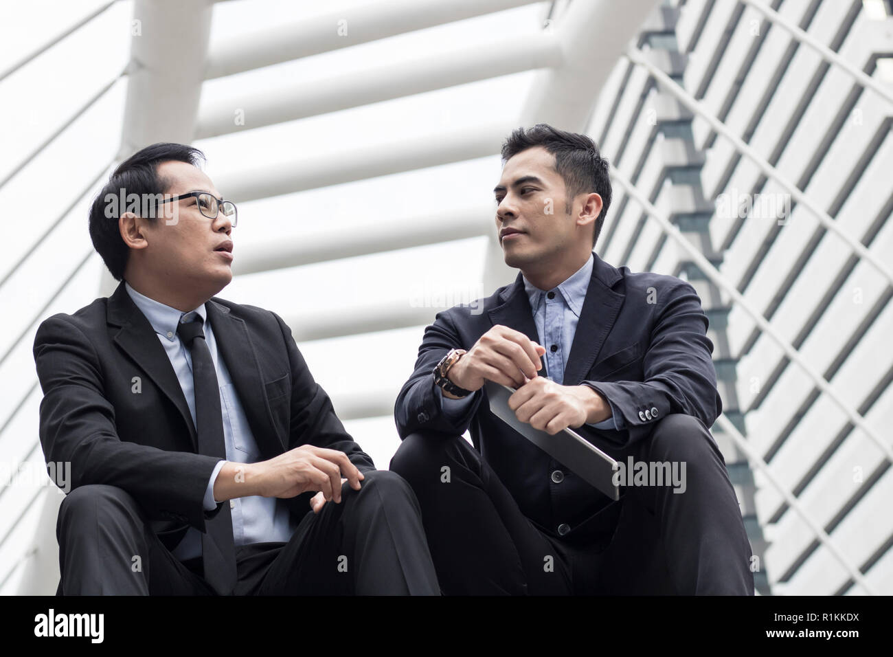 Two men sitting on stairs talking hi-res stock photography and images ...