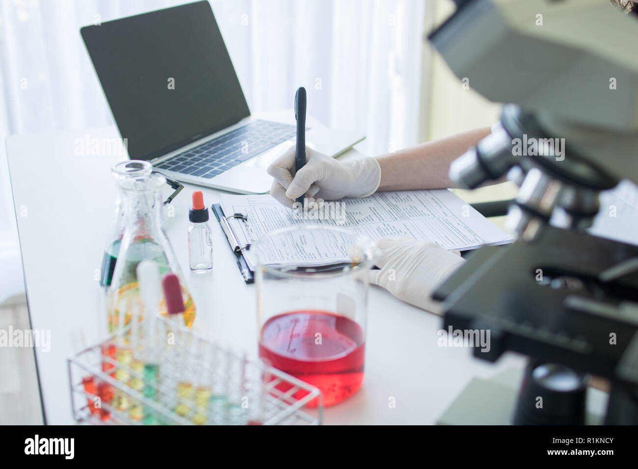 researcher or scientist writing information result and note on paper in ...