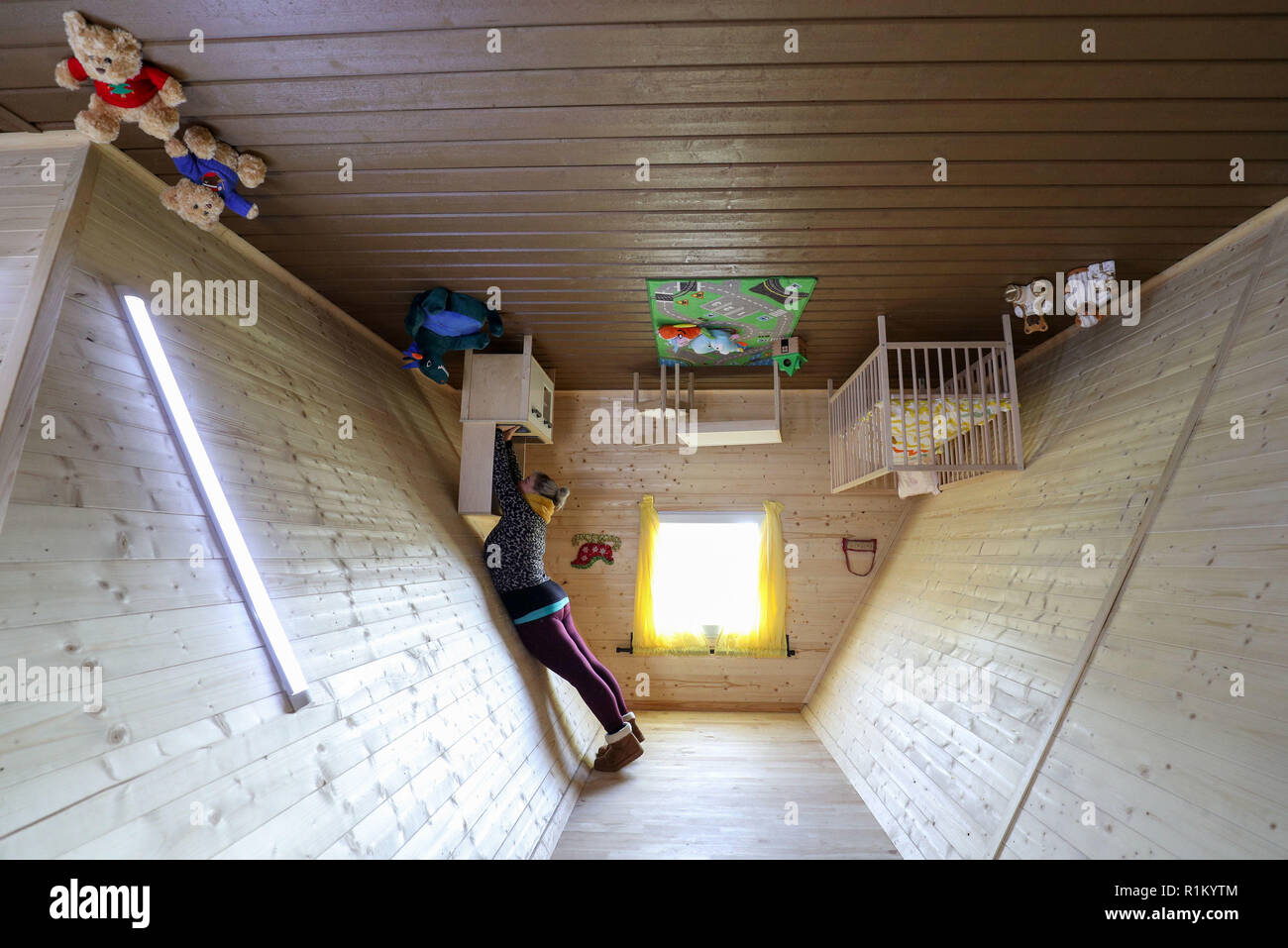 An employee in a bedroom in 'The Upside Down House', a zero-gravity ...