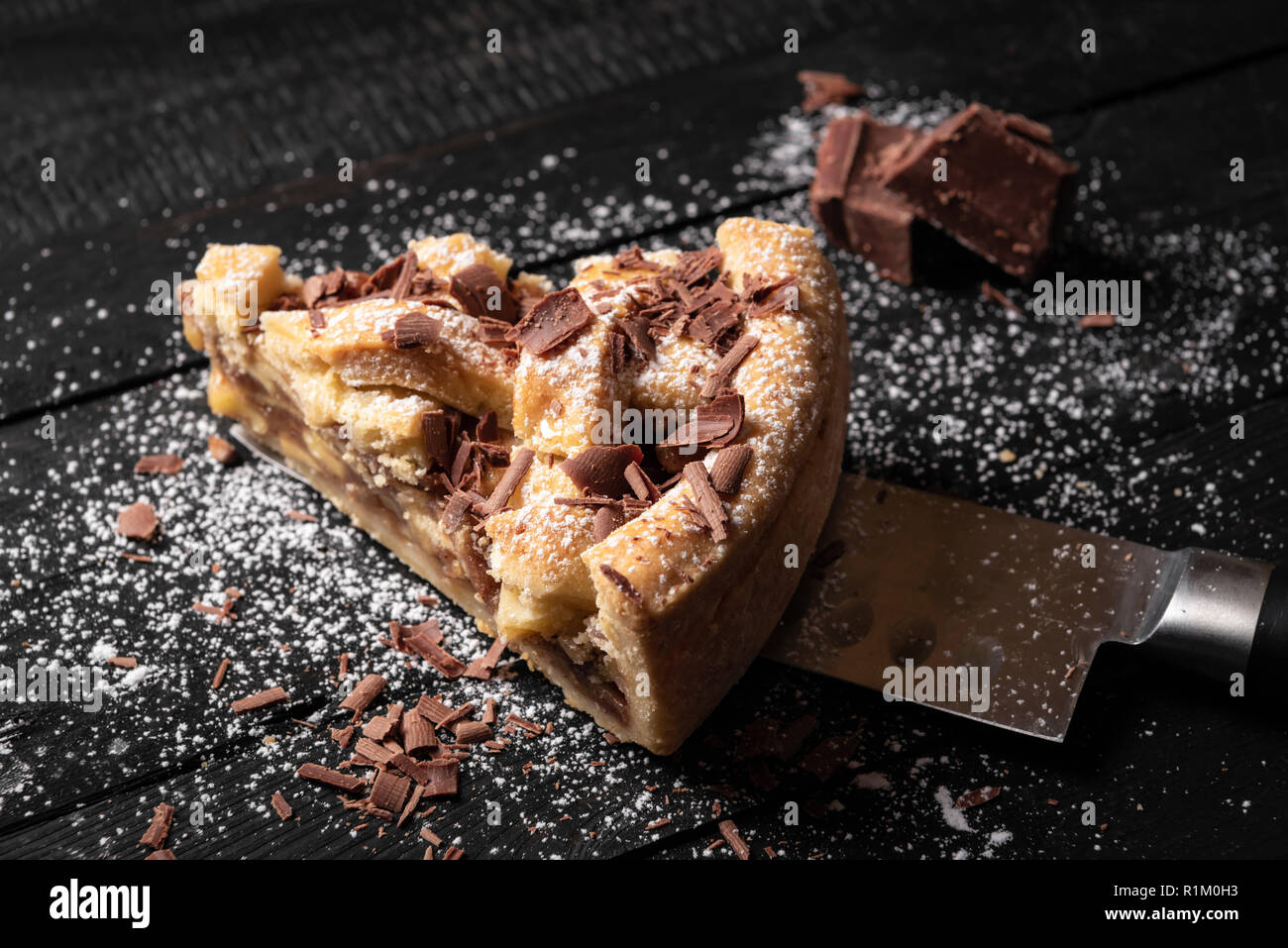 Close-up image of a piece of apple pie on a knife, decorated with ...