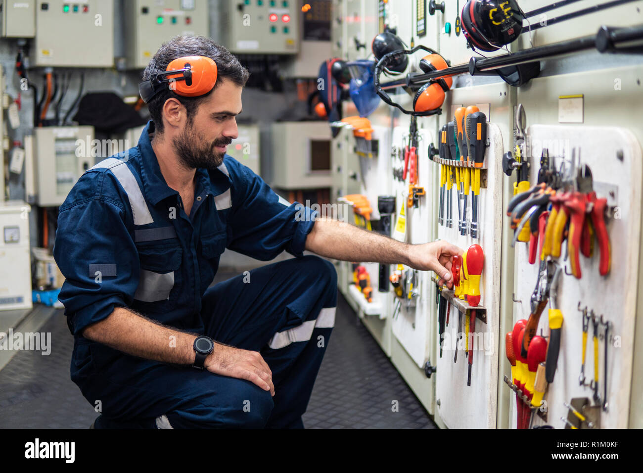 Marine engineer officer working in engine room Stock Photo - Alamy