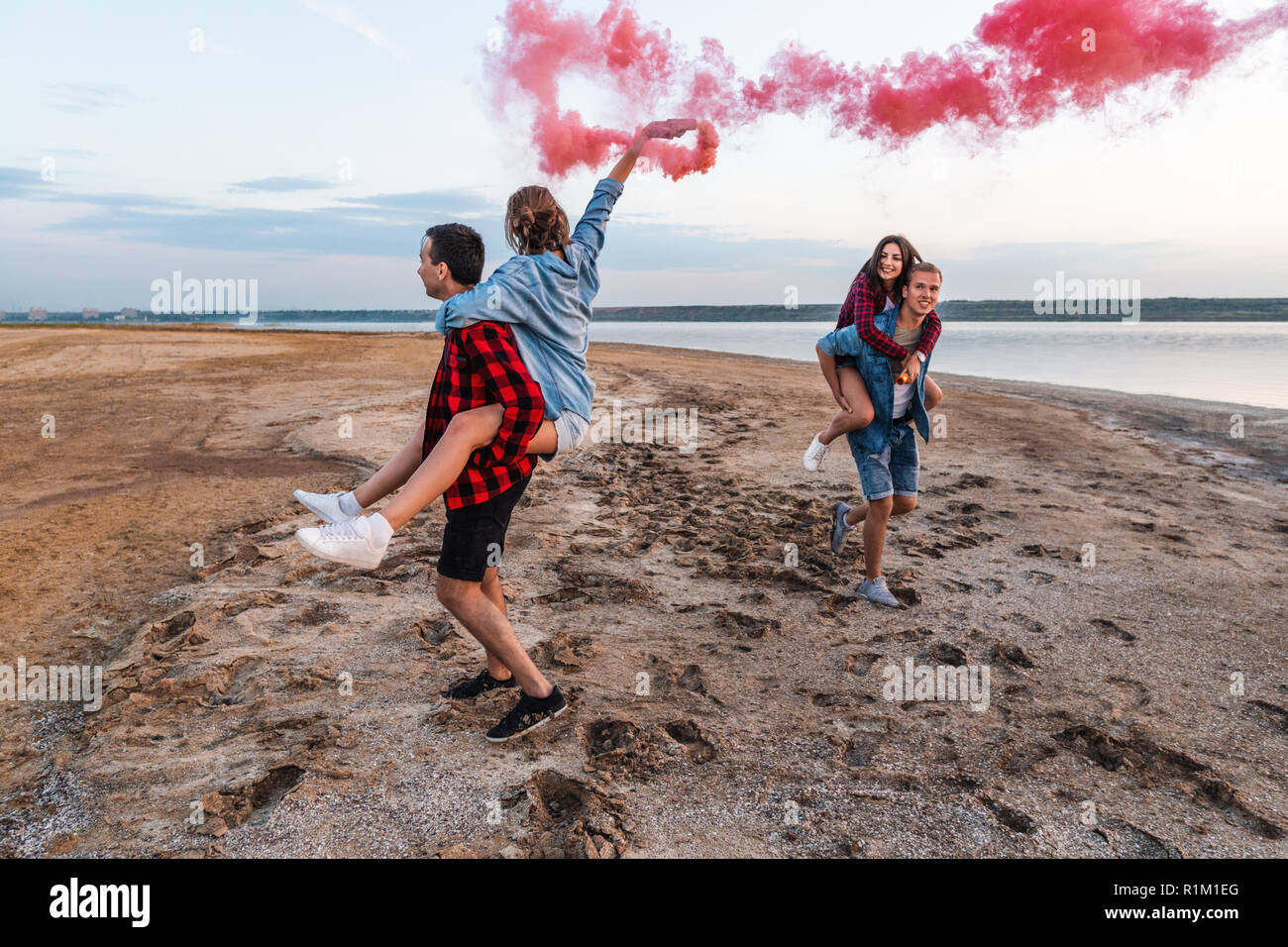 young friends running with hand flare or fusee Stock Photo - Alamy