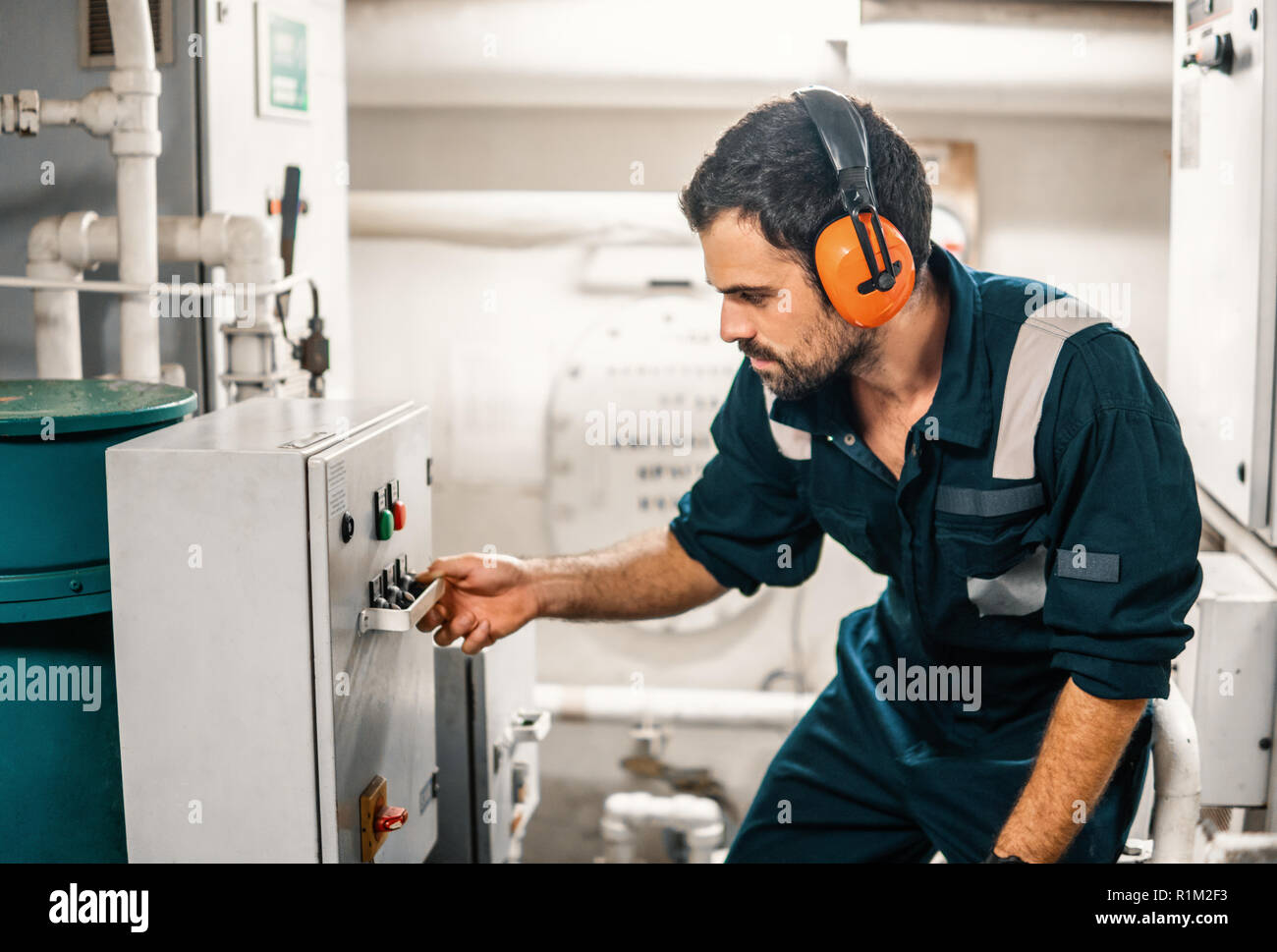 Marine engineer officer working in engine room Stock Photo - Alamy