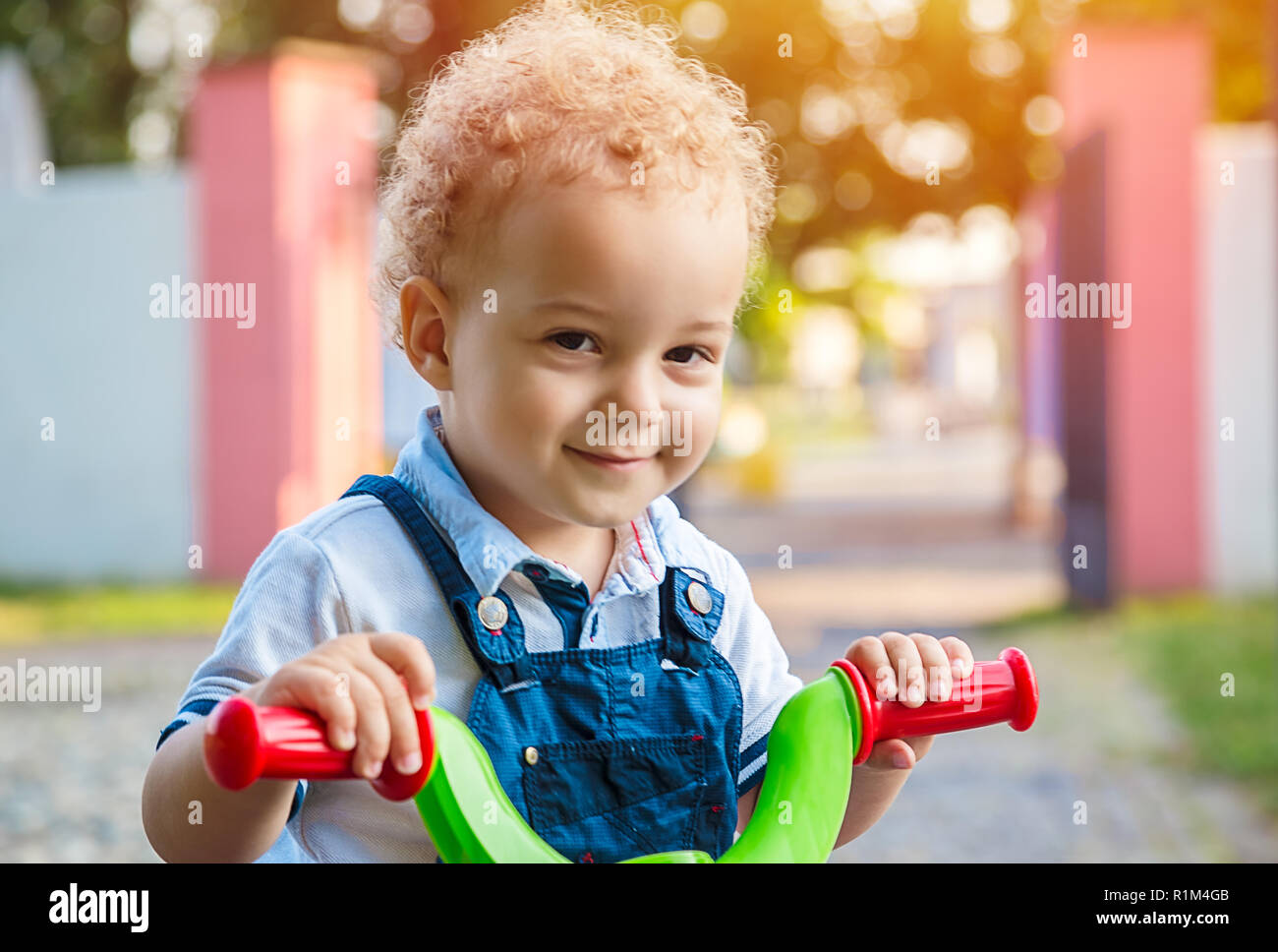 Smiling children baby boy riding bicycle outdoor Stock Photo - Alamy