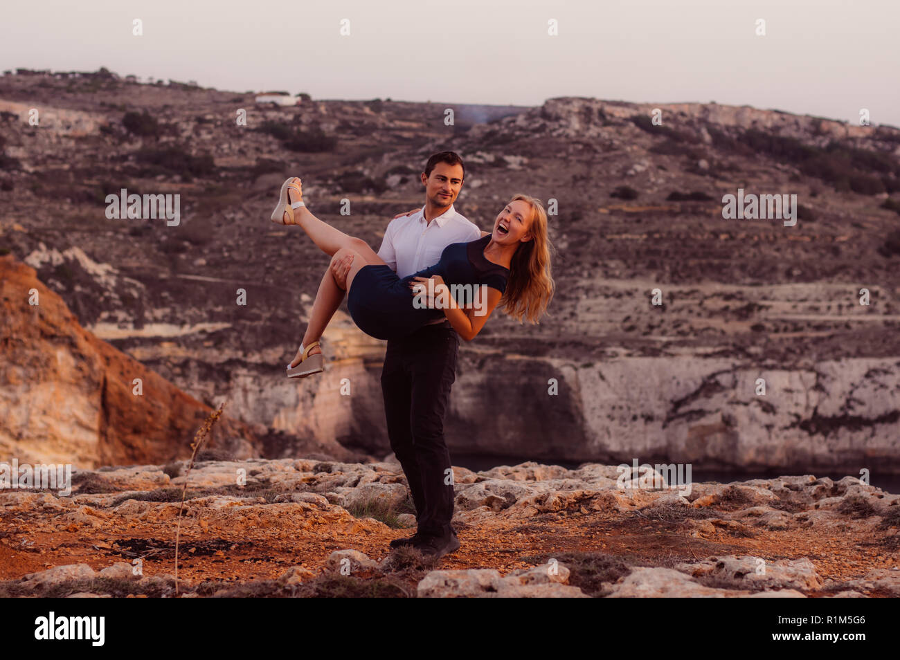 Man carry on hands woman in the evening on the seaside, beautiful dusk ...