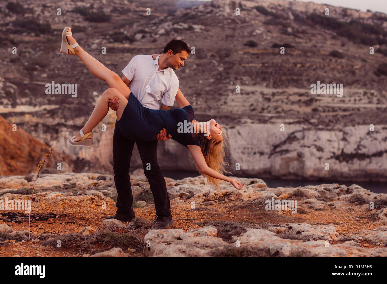 Man carry on hands woman in the evening on the seaside, beautiful dusk ...