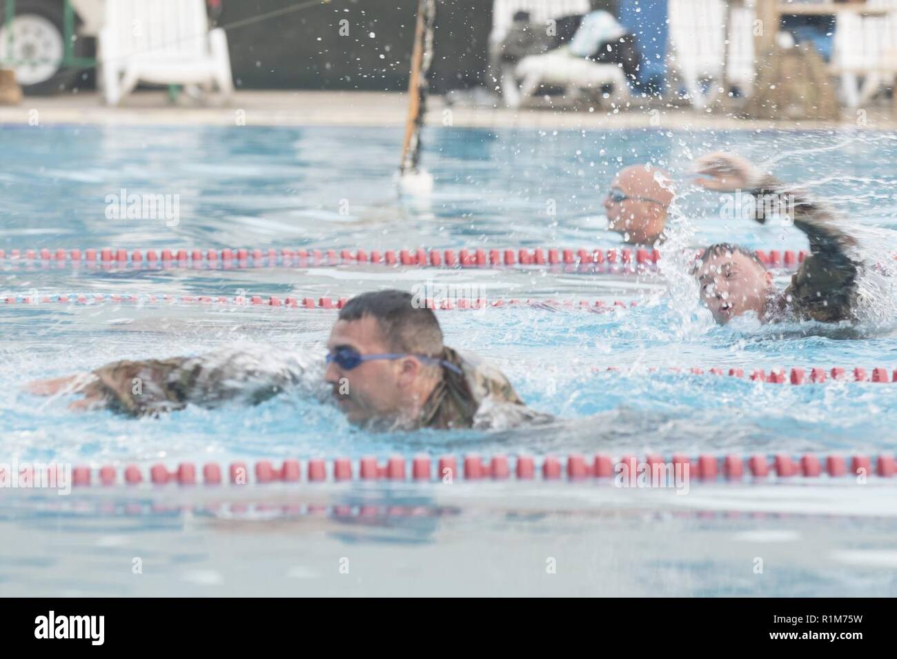 U.S. Army Soldiers race to complete the 100 meter swim event of the ...