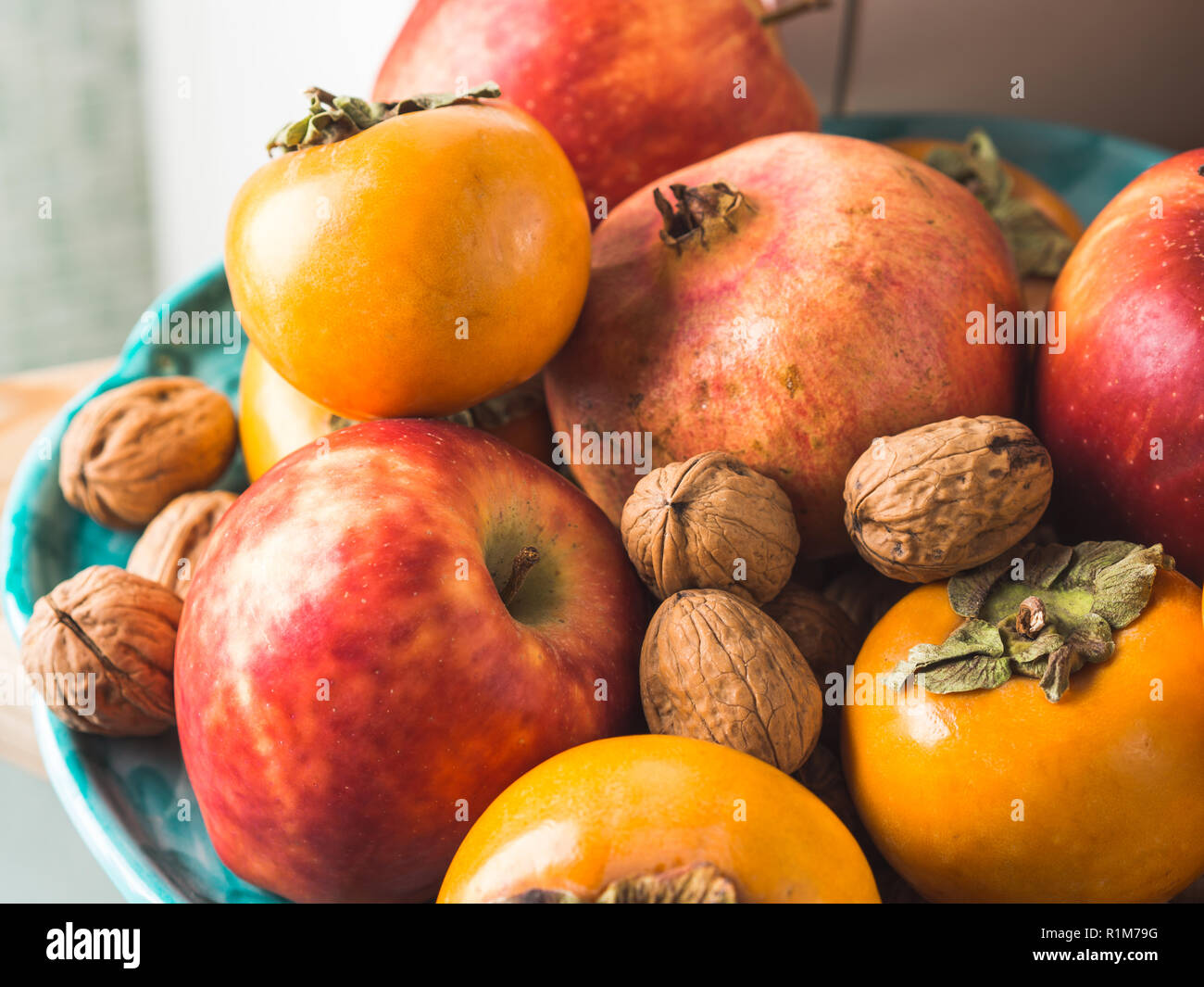 Autumn fresh fruit food persimmons, pomegranate, apples, nuts, in the ...
