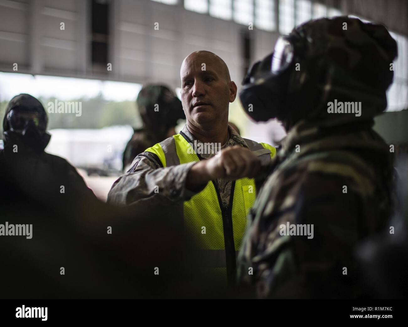 Staff Sgt. Andrew Marsala instructs the proper fit of the JLIST suit ...