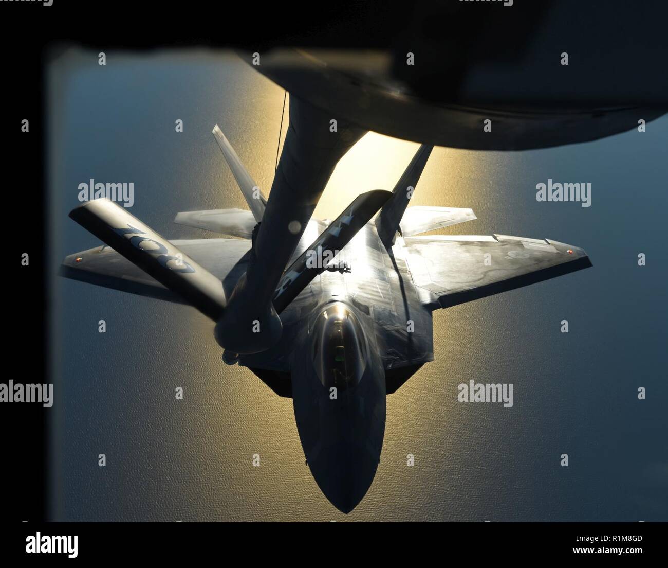 A U.S. Air Force F-22 Raptor flies behind a U.S. Air Force KC-135 ...