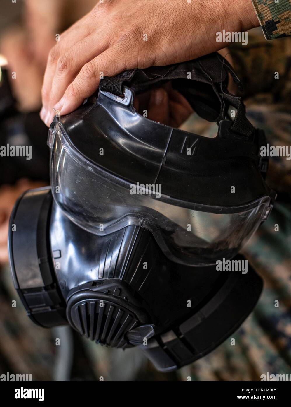 A U.S. Marine Corps recruit with Company K, adjusts a M40 gas mask ...