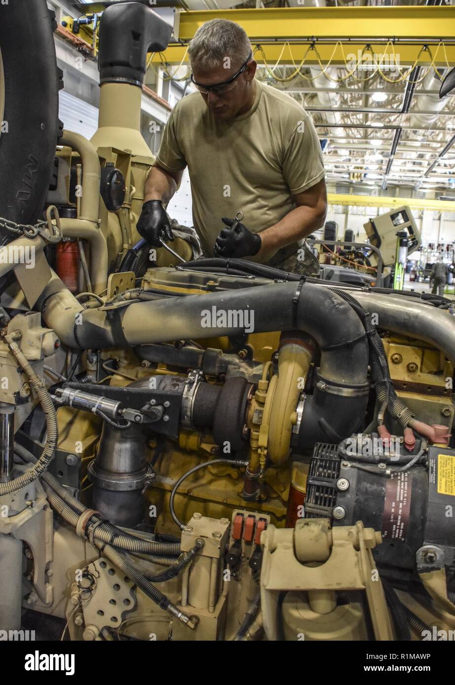 An Army mechanic makes a final adjustment under the hood to ensure our ...