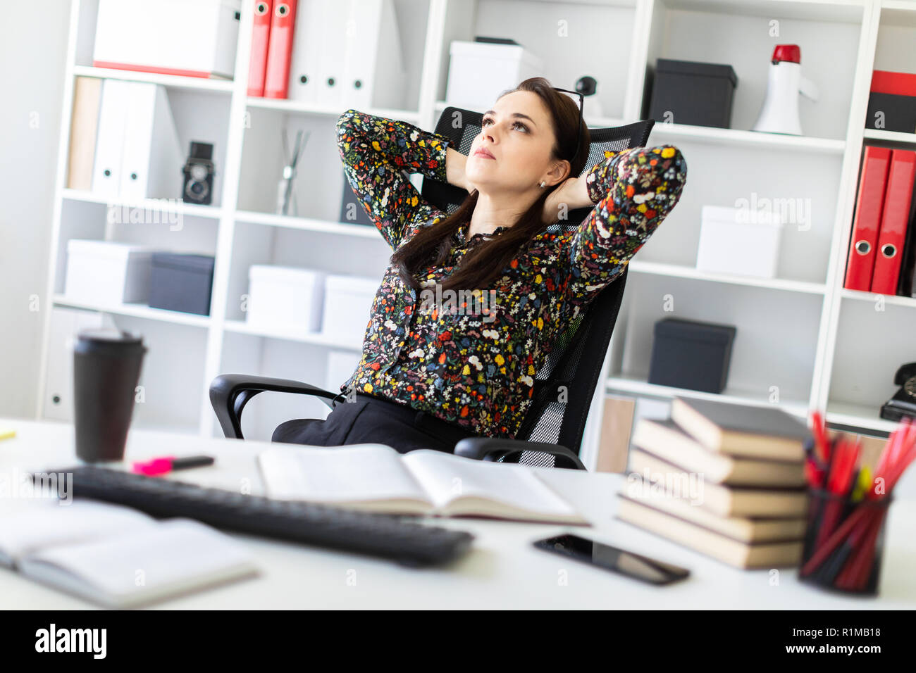 A young girl sitting in the office at the computer table Stock Photo ...