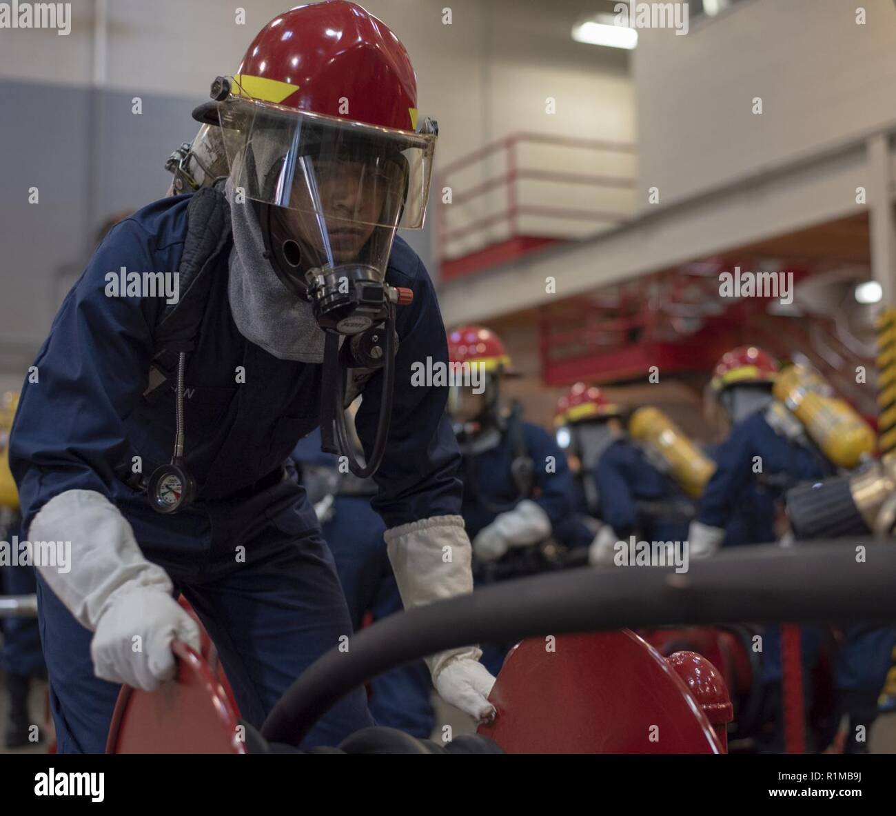 GREAT LAKES, Ill. (Oct. 23, 2018) A recruit reels in a hose after ...