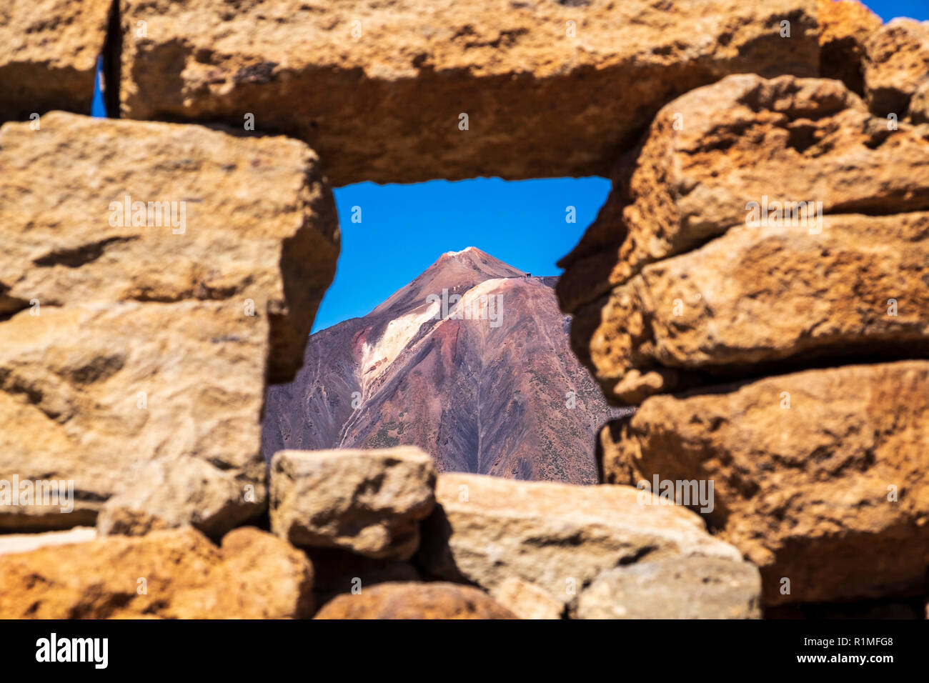 Teide summit framed by a window of rocks in the old observatory on the ...
