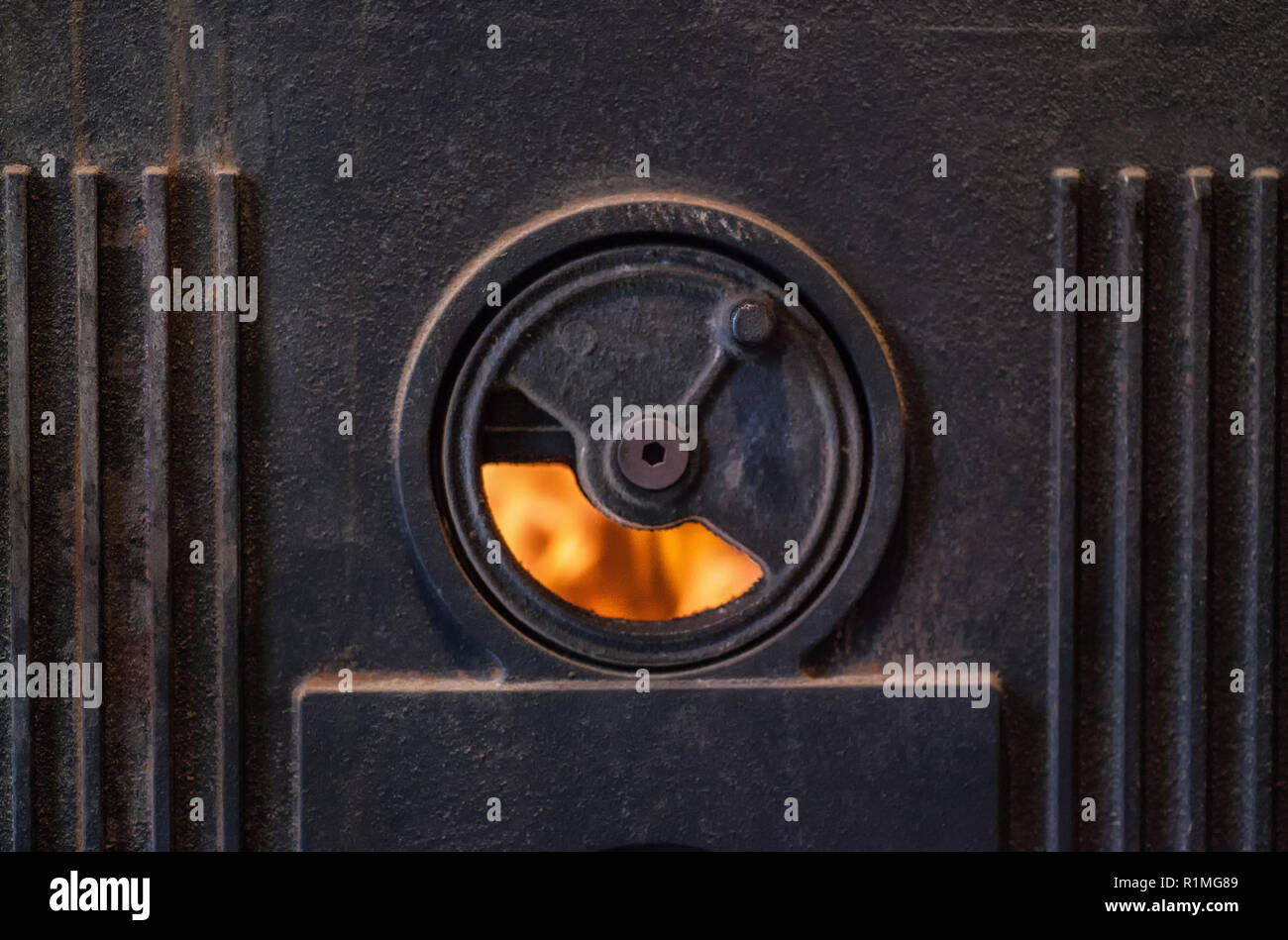 Old, cast iron, rusty stove. The fire in the furnace. Background. Close ...
