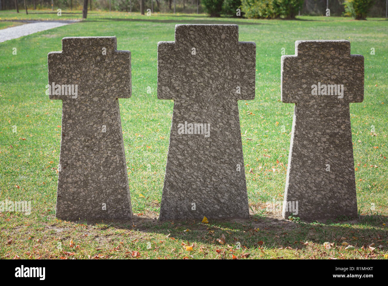 close up image of memorial stone crosses placed in row at graveyard ...