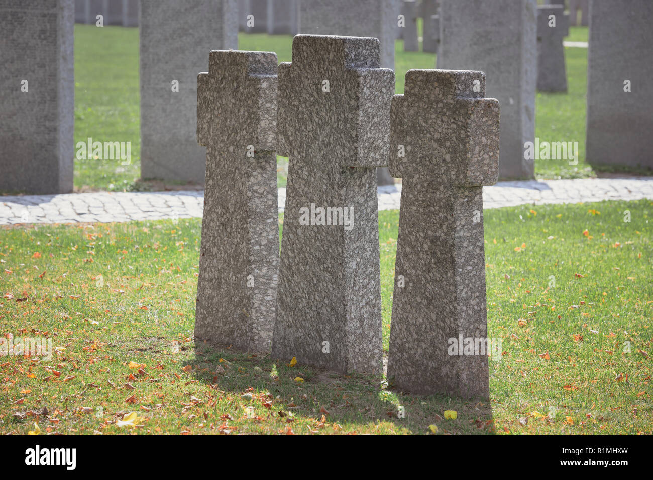 selective focus of identical old memorial headstones placed in row at ...