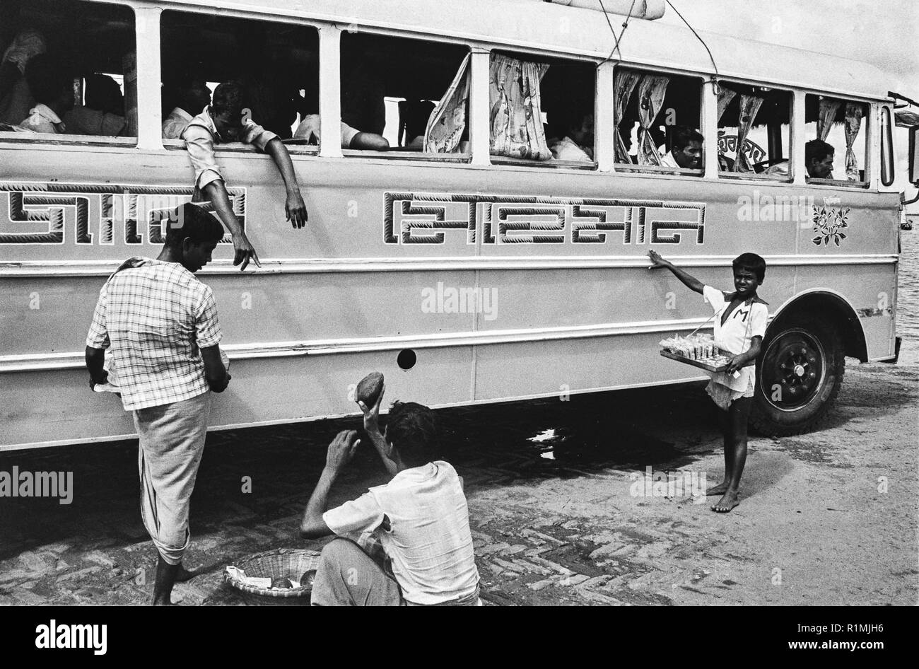 Vendors at bus stop at ferry port 1980 Stock Photo - Alamy