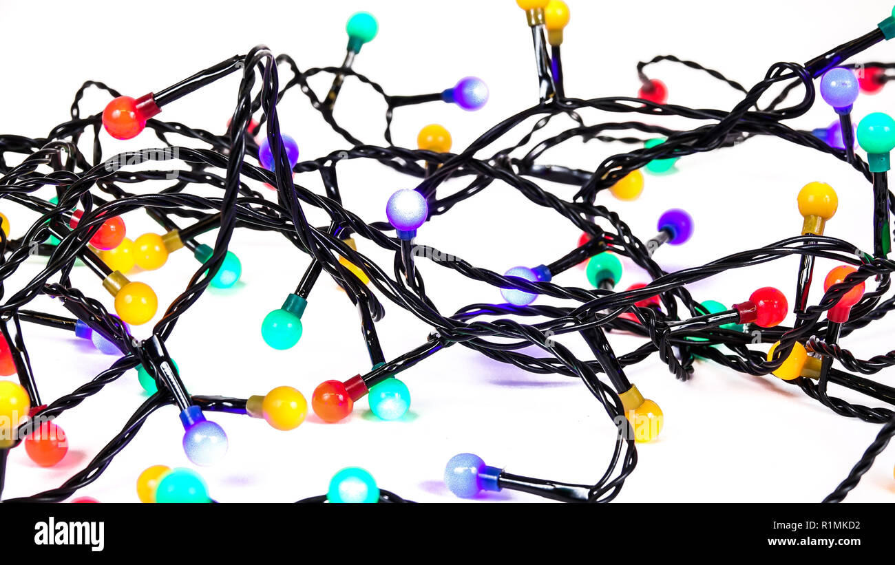 Colorful christmas lights over white background. Messy tangled cables ...