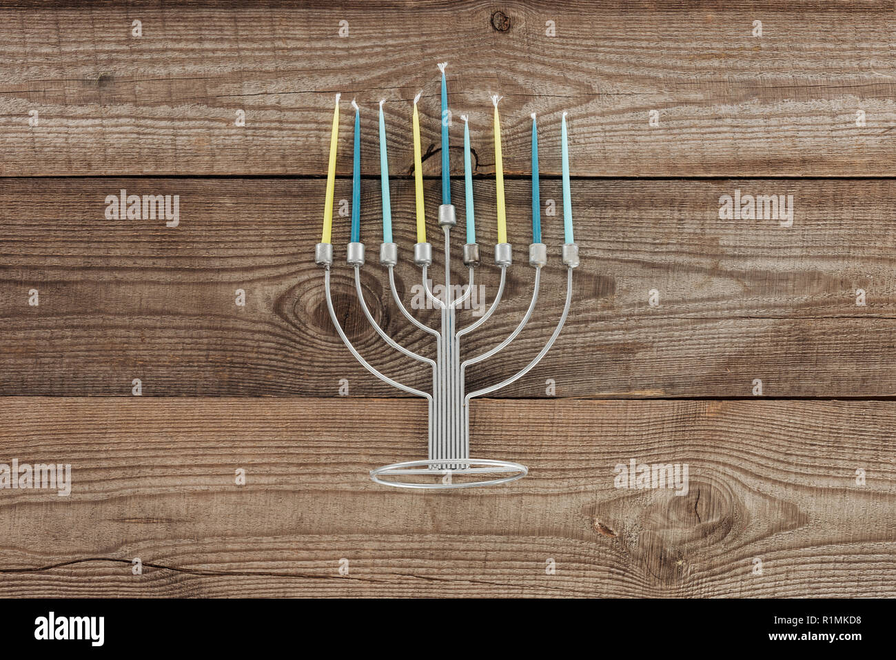 top view of traditional jewish menorah with blue and yellow candles on ...