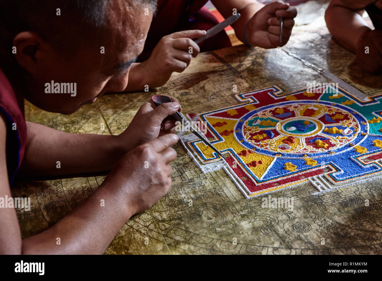 Buddhist monks creating a mandala of colored sand in Lamayuru monastery ...