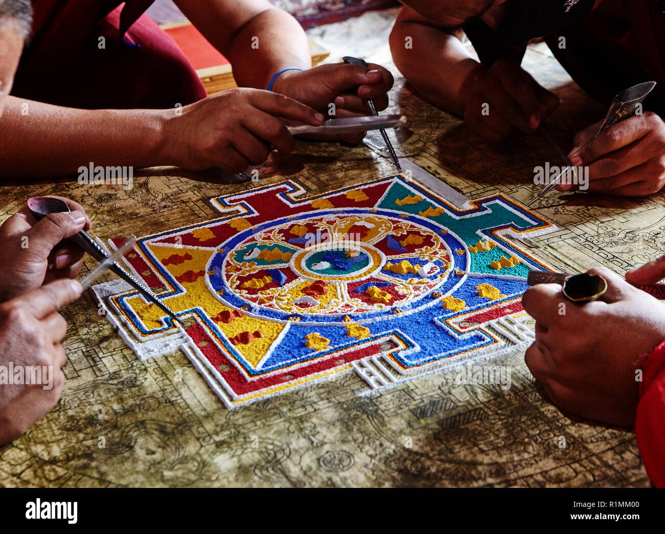 Buddhist monks creating a mandala of colored sand in Lamayuru monastery ...