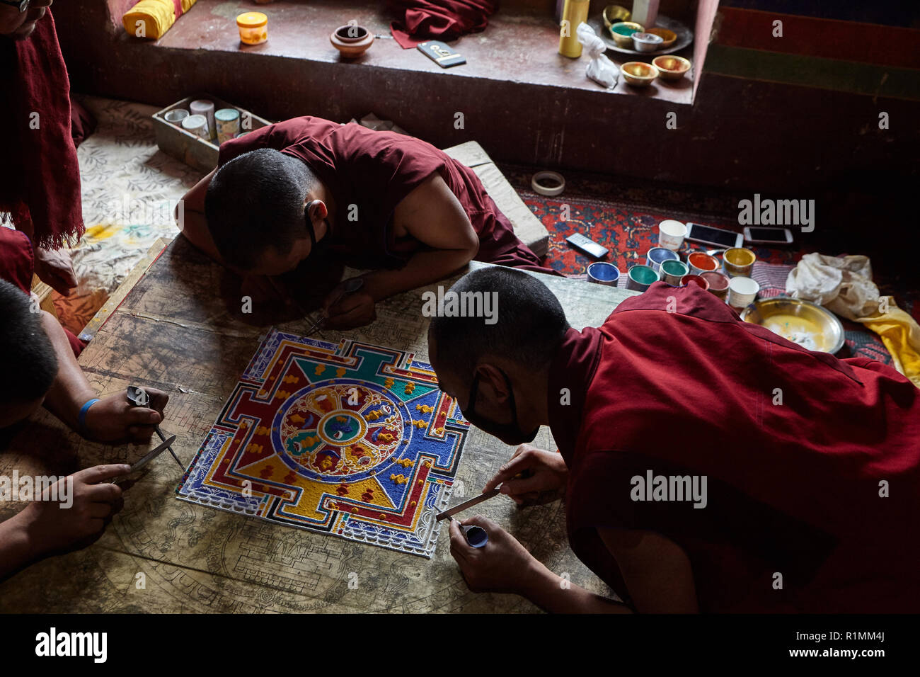 Buddhist monks creating a mandala of colored sand in Lamayuru monastery ...