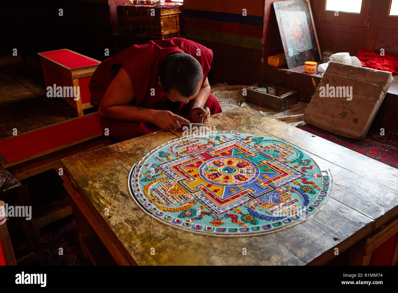 Buddhist monk creating a mandala of colored sand in Lamayuru monastery ...