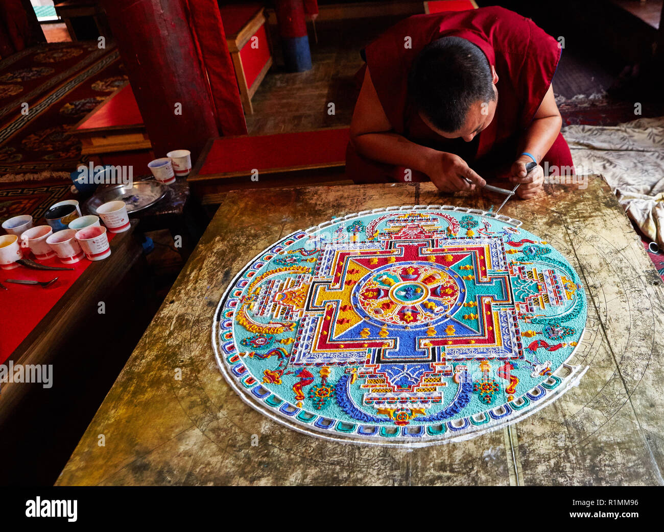Buddhist monk creating a mandala of colored sand in Lamayuru monastery ...